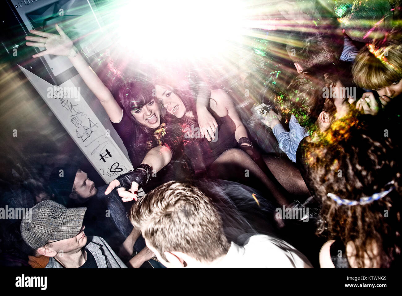 Two girls are having a great time in an underground club with a packed ...