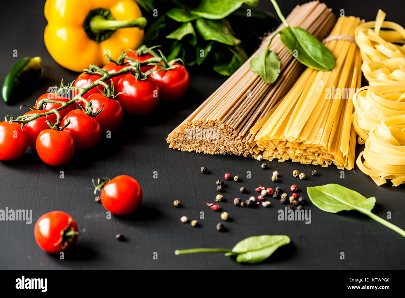 Raw italian pasta.Spaghetti and fettuccine with tomatoes, vegetables ...