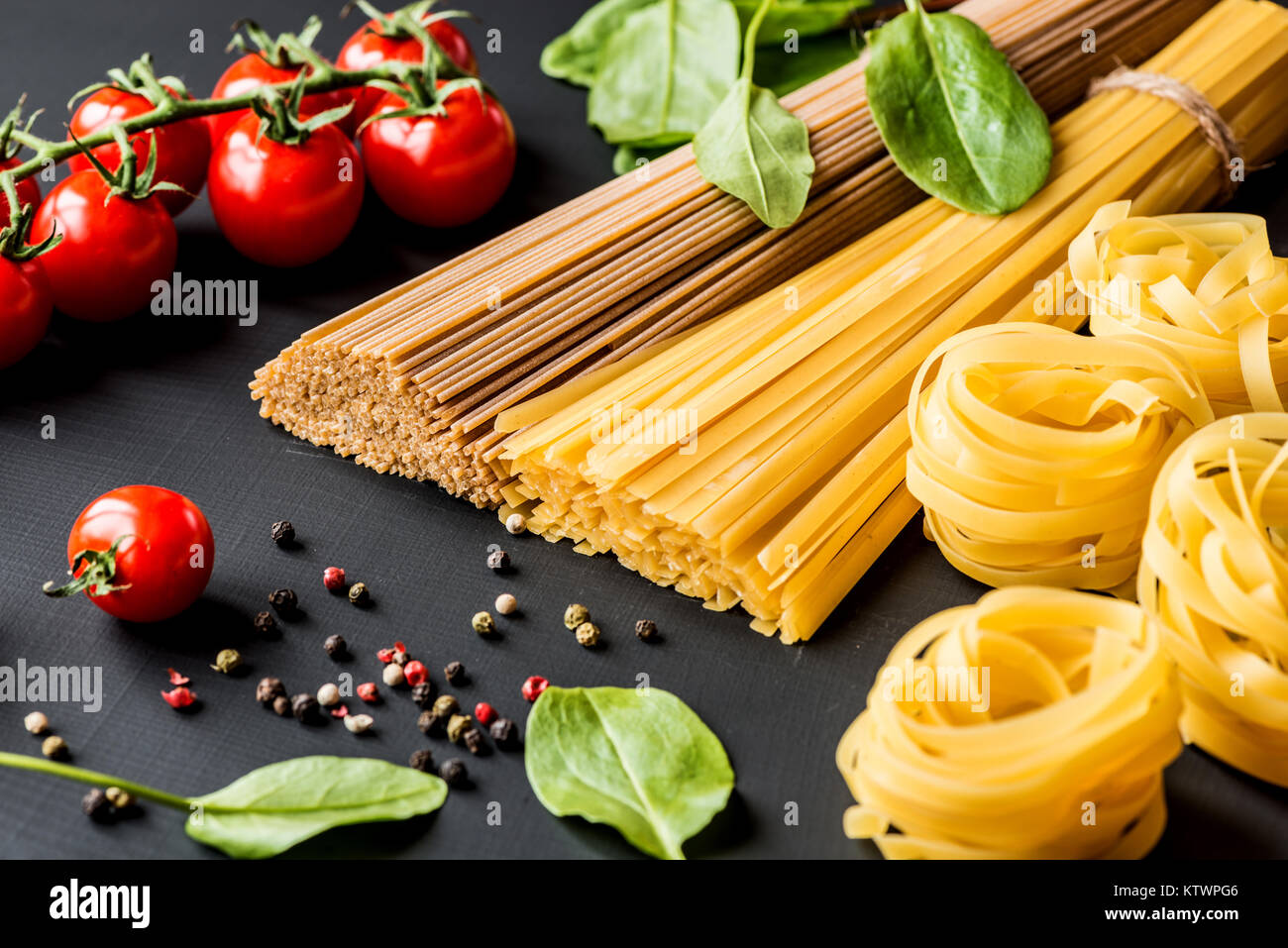 Raw italian pasta.Spaghetti and fettuccine with tomatoes, herbs and ...