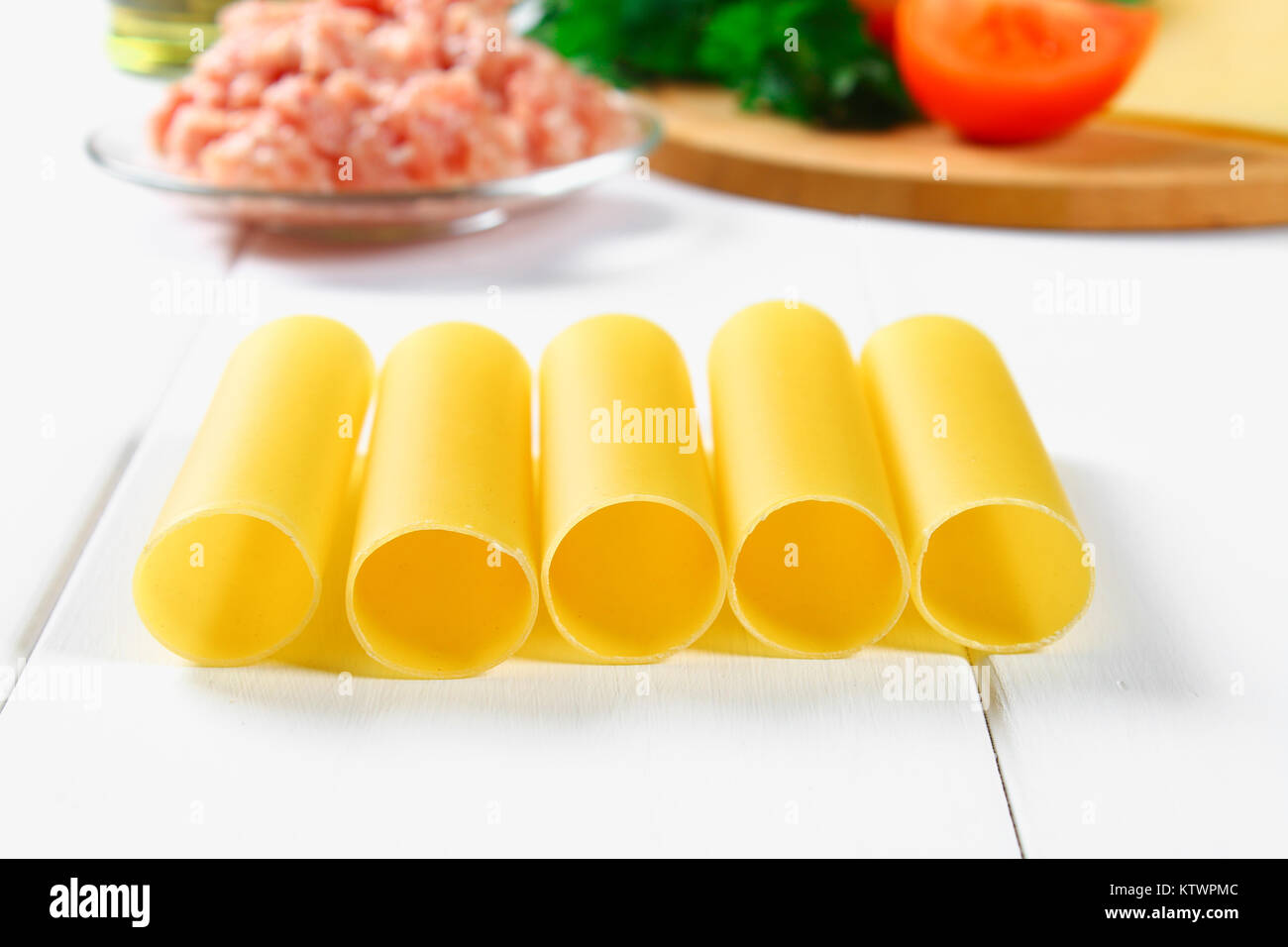 Italian pasta cannelloni. Raw tube for stuffing stuffing surrounded by ...