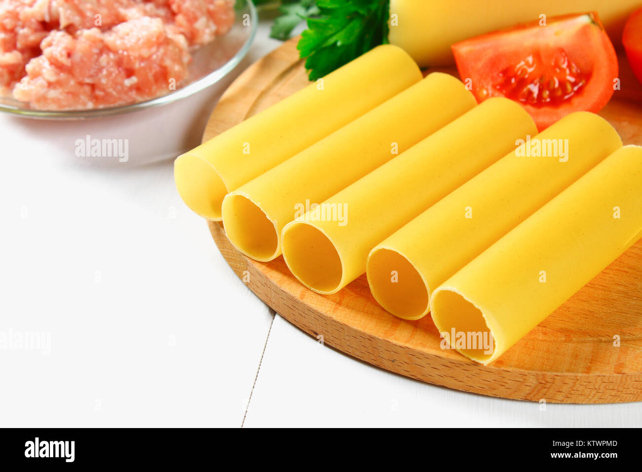 Italian pasta cannelloni. Raw tube for stuffing stuffing surrounded by ...