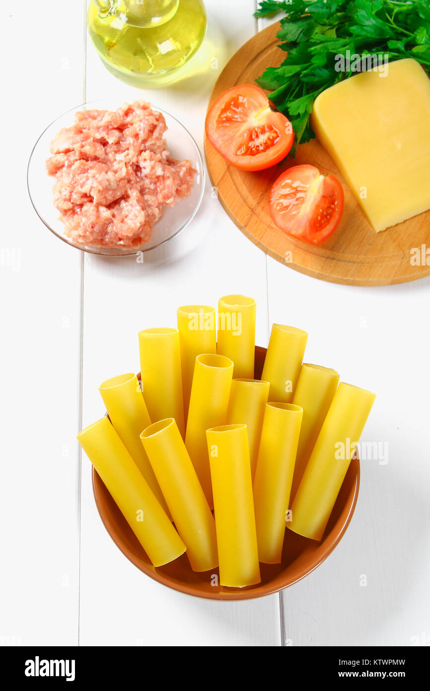 Italian pasta cannelloni. Raw tube for stuffing stuffing surrounded by ...