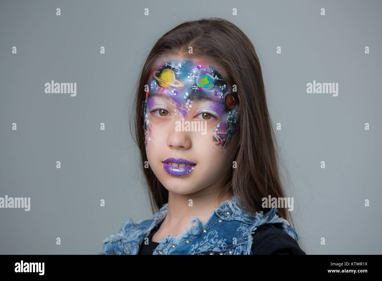 Portrait of a small beautiful Kazakh girl on a gray background with a ...