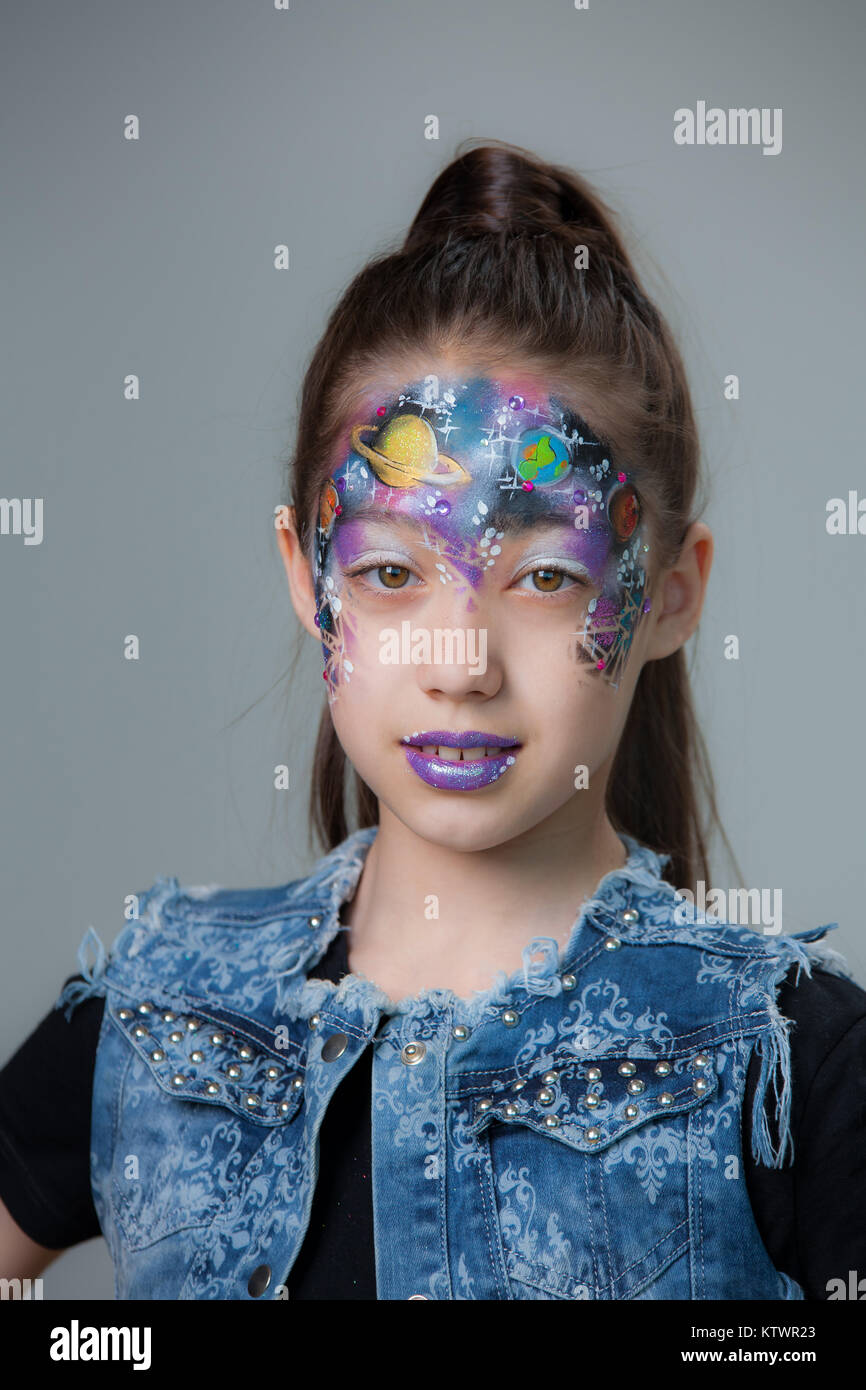 Portrait of a small beautiful Kazakh girl on a gray background with a ...
