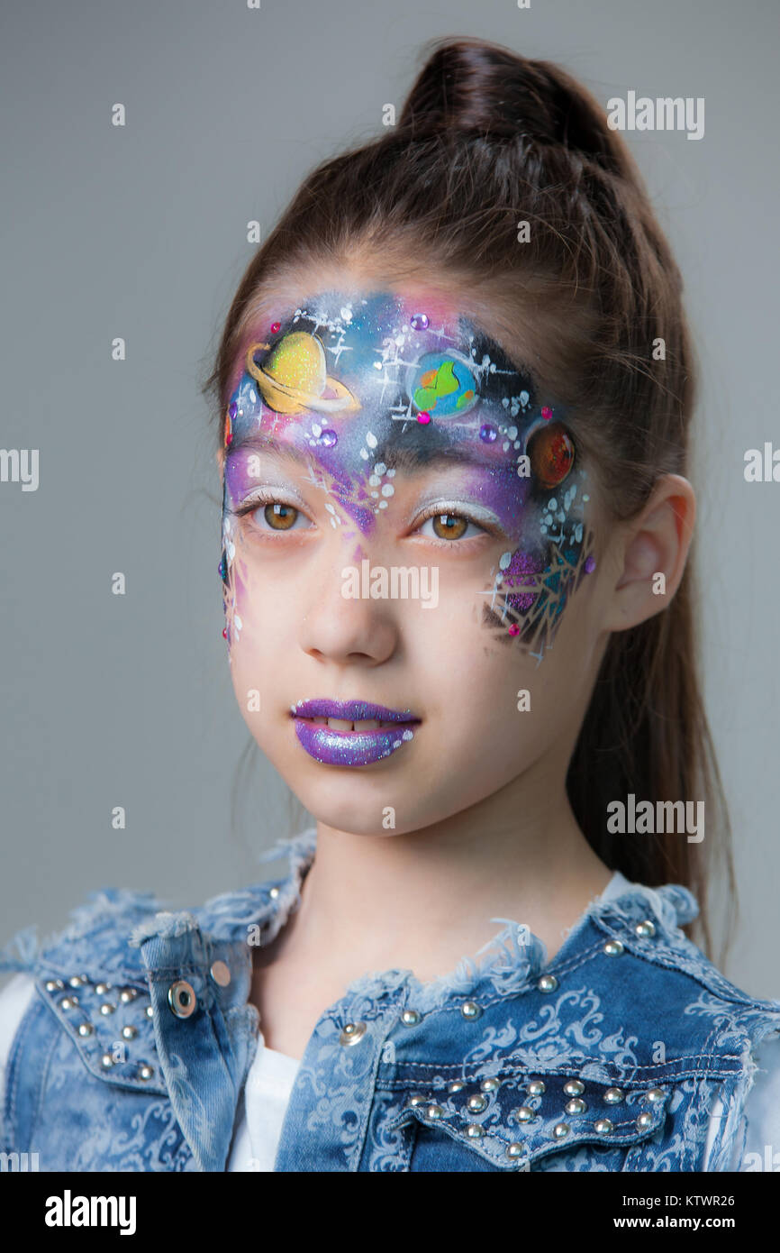 Portrait of a small beautiful Kazakh girl on a gray background with a ...