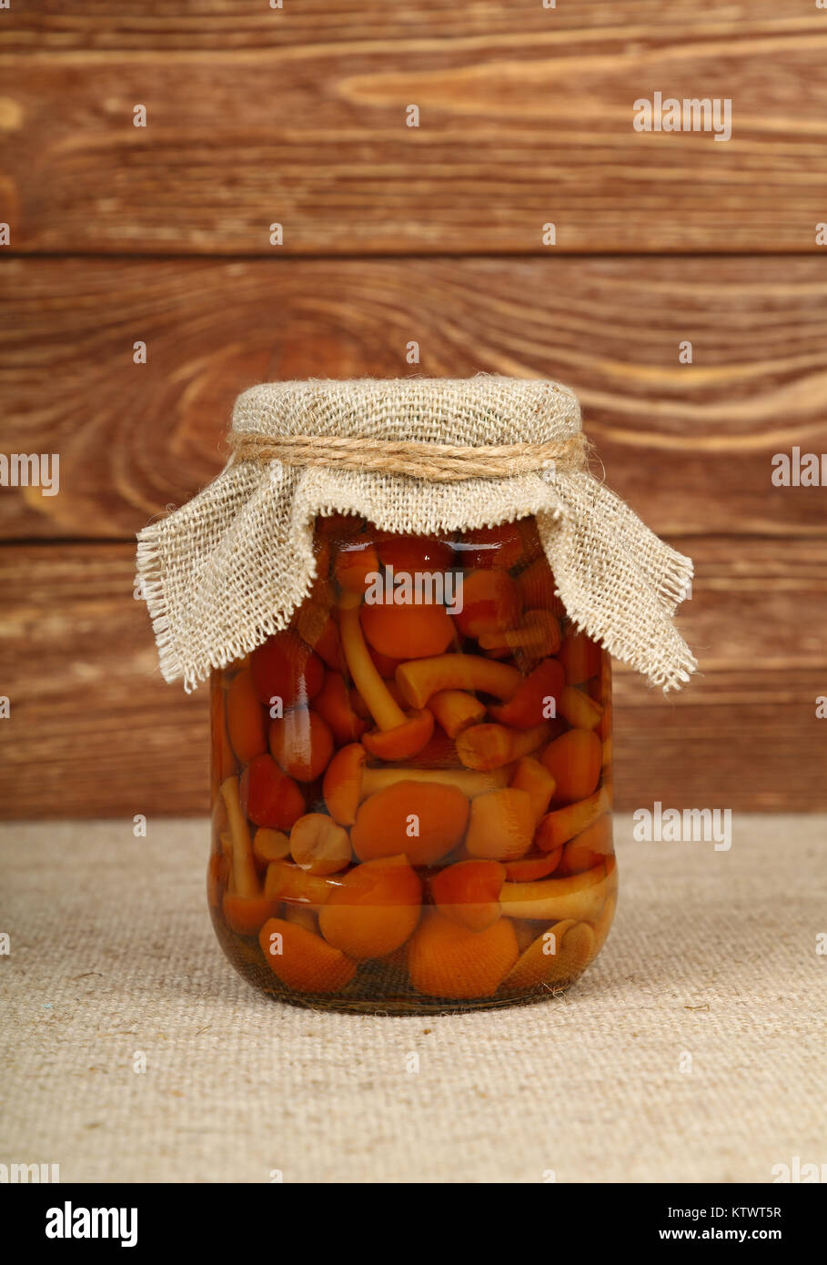 Close up of one glass jar of pickled small brown honey fungus ...