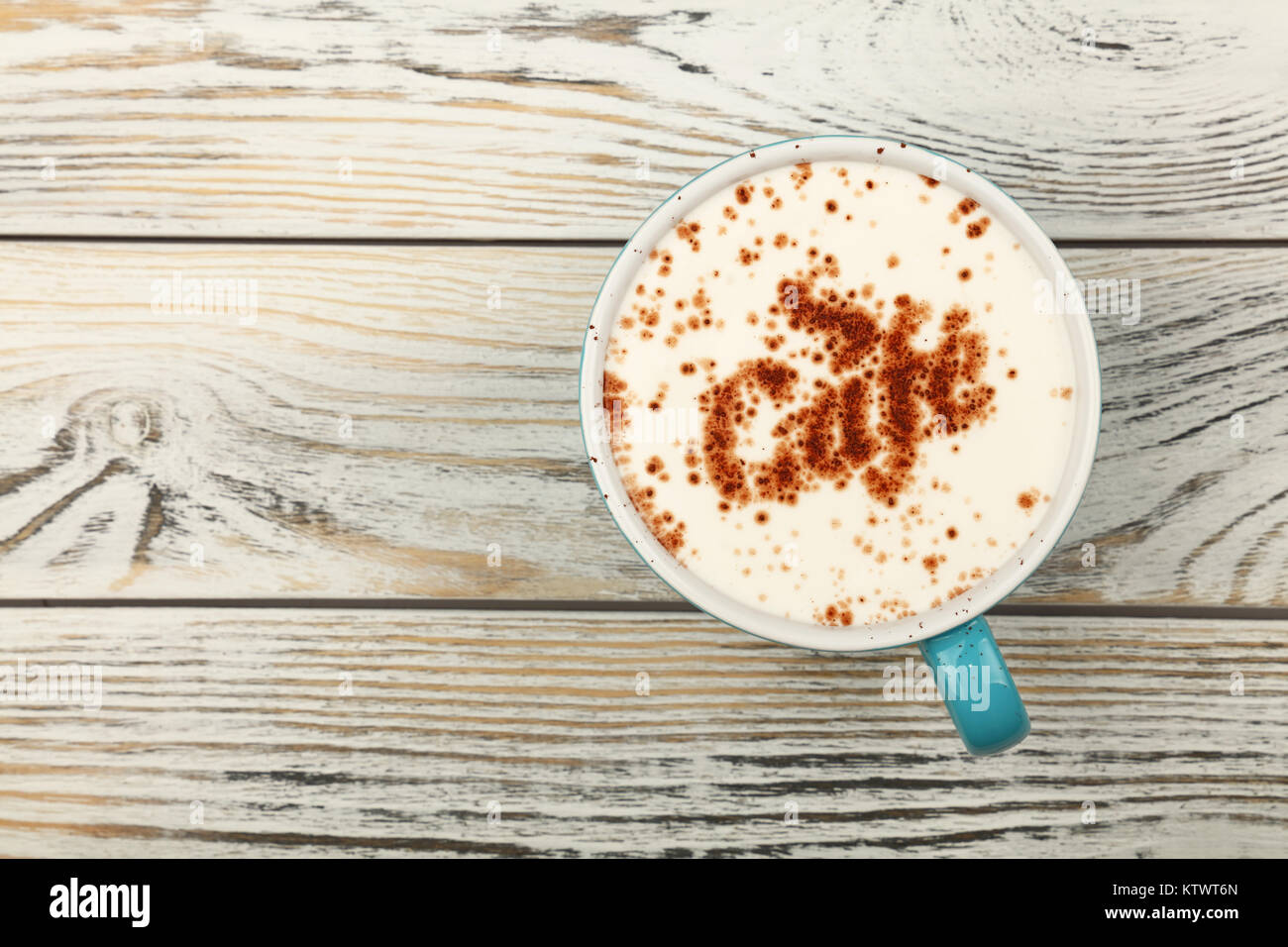 Close up blue cup full of latte cappuccino coffee with CAFE word shaped ...