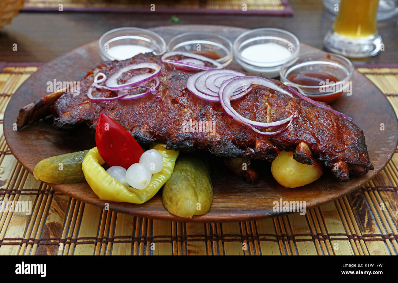 Rack of grill roasted pork spare ribs with onion rings, pepper and ...
