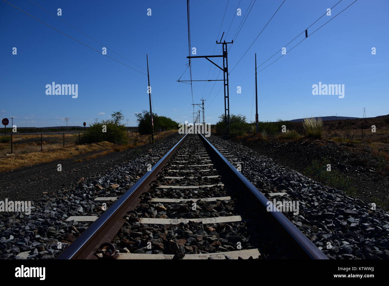 Train tracks shot at a low angle converging into a vanishing point on ...