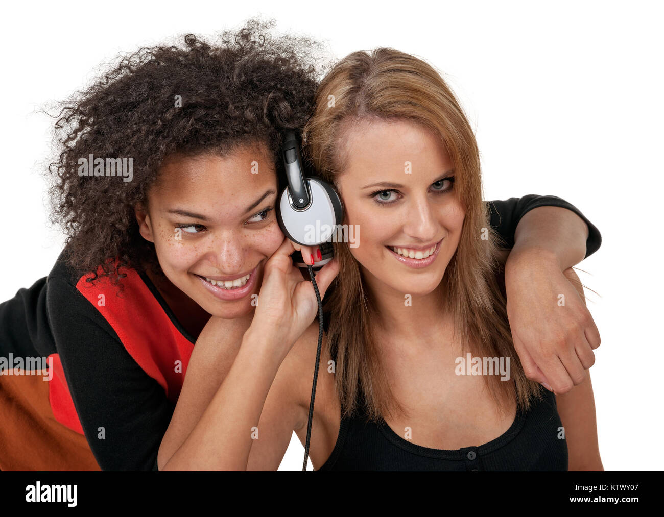 Best friends enjoying music together by sharing the headphone with each ...