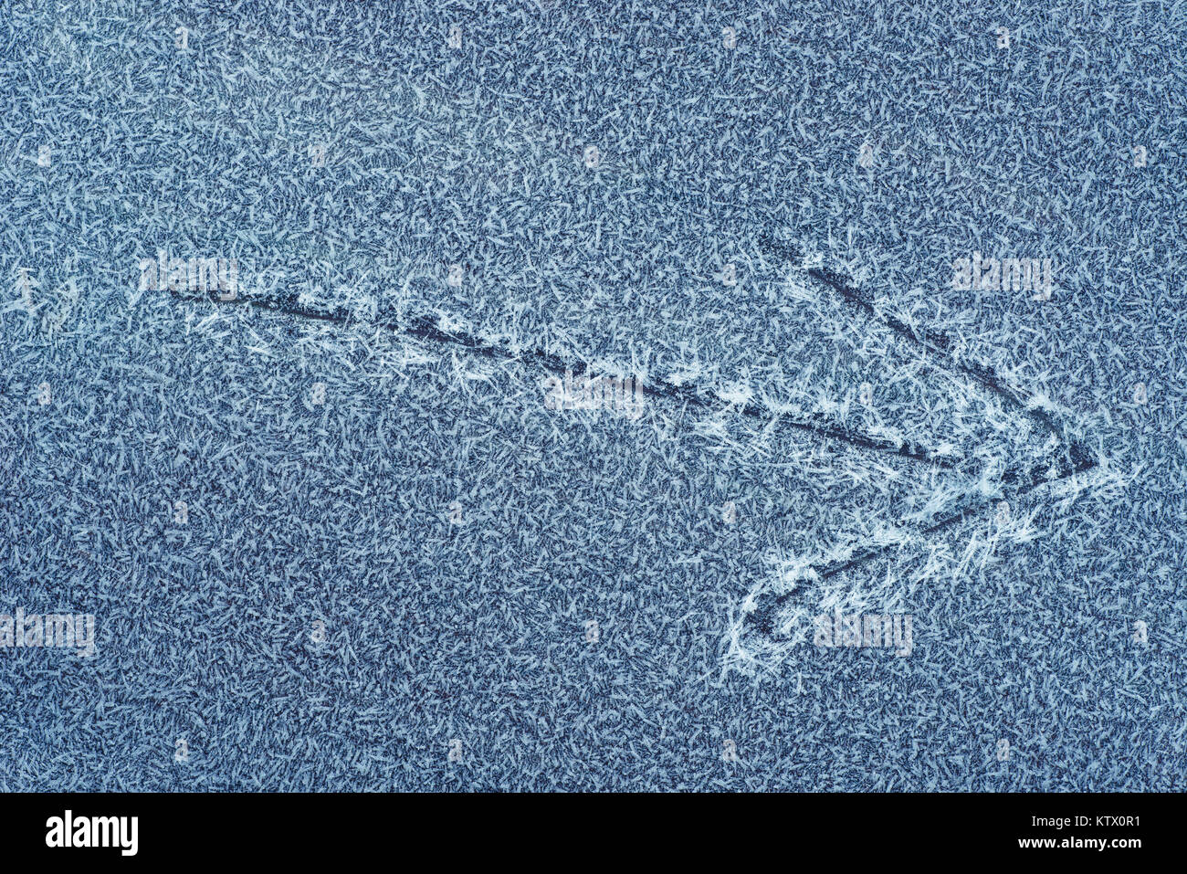 arrow sign on hoarfrost background Stock Photo - Alamy