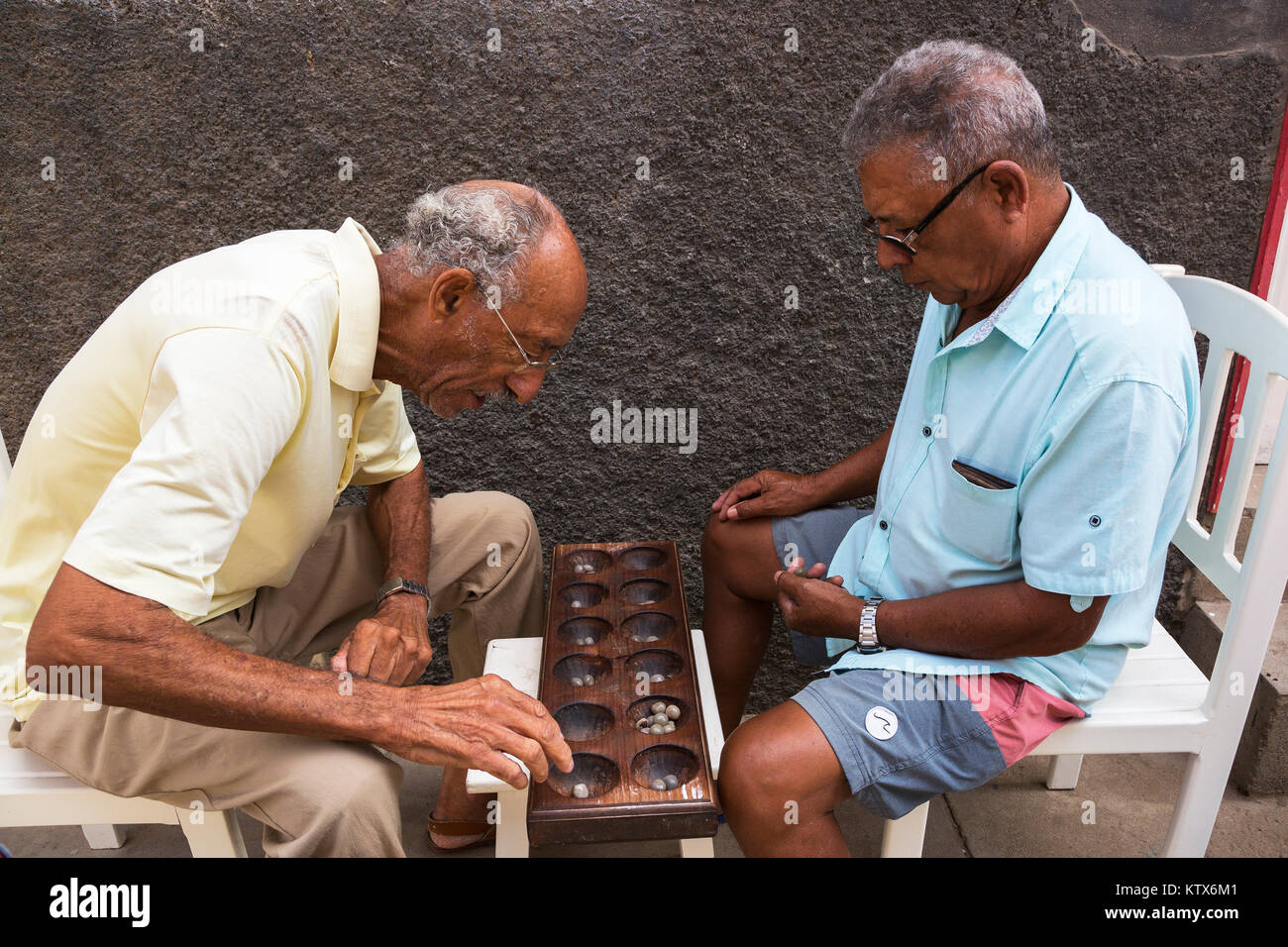 Local men playing the traditional board game ouril also known as oware ...