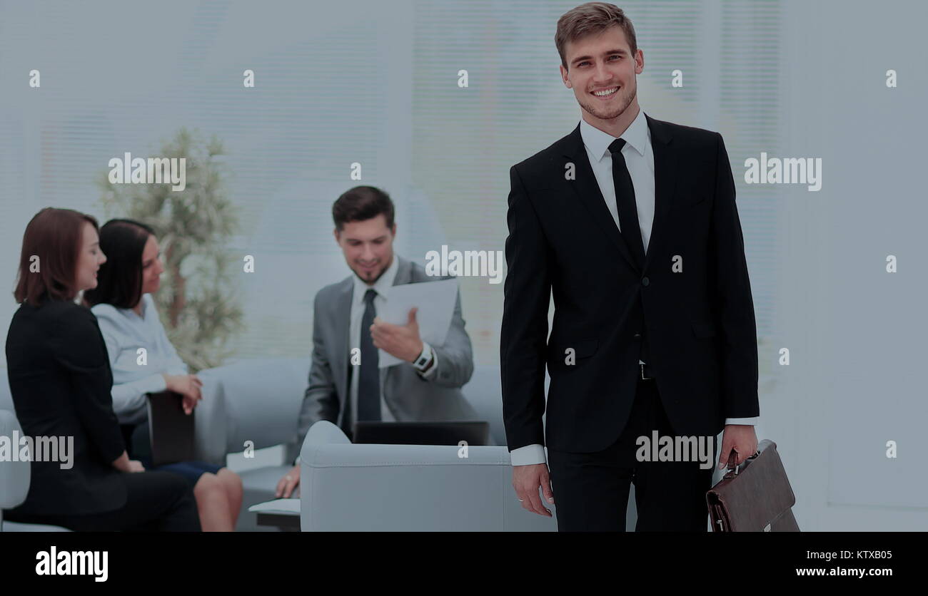 Successful business man standing with his staff in background at Stock ...