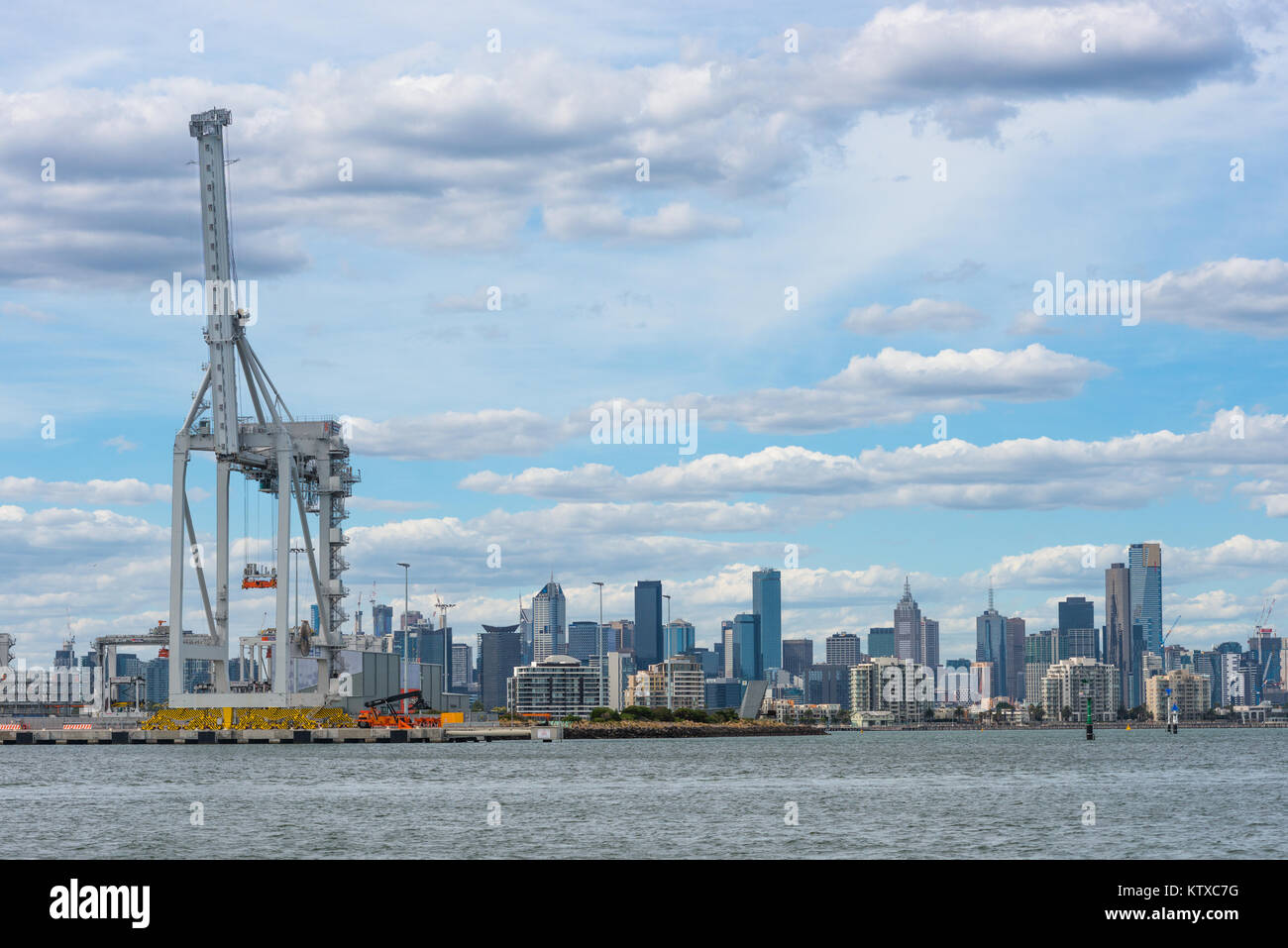 Container quayside crane in the Port of Melbourne with city skyline ...