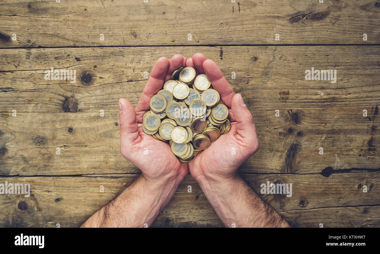 man hands holding a stack of euro coins, top view, with copy space ...