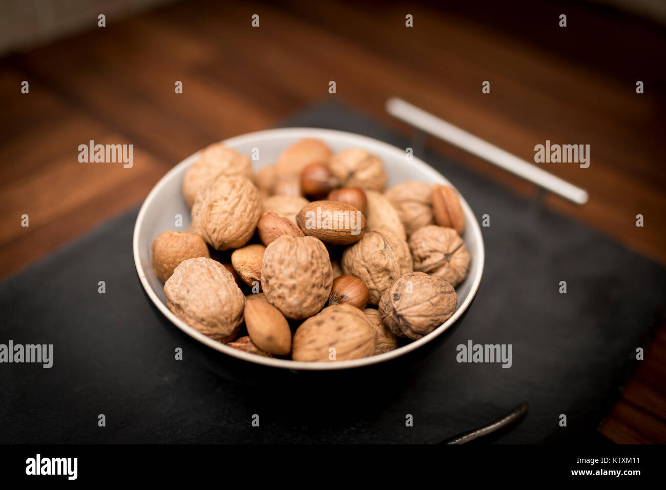 A bowl of mixed whole nuts in their shells including walnuts, hazelnuts ...