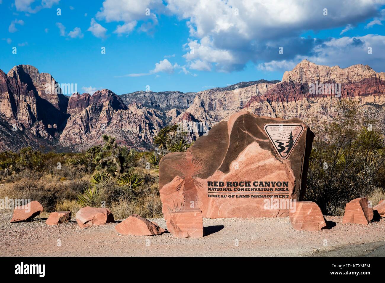 A welcome sign sits in front of the red sandstone rock formations at ...