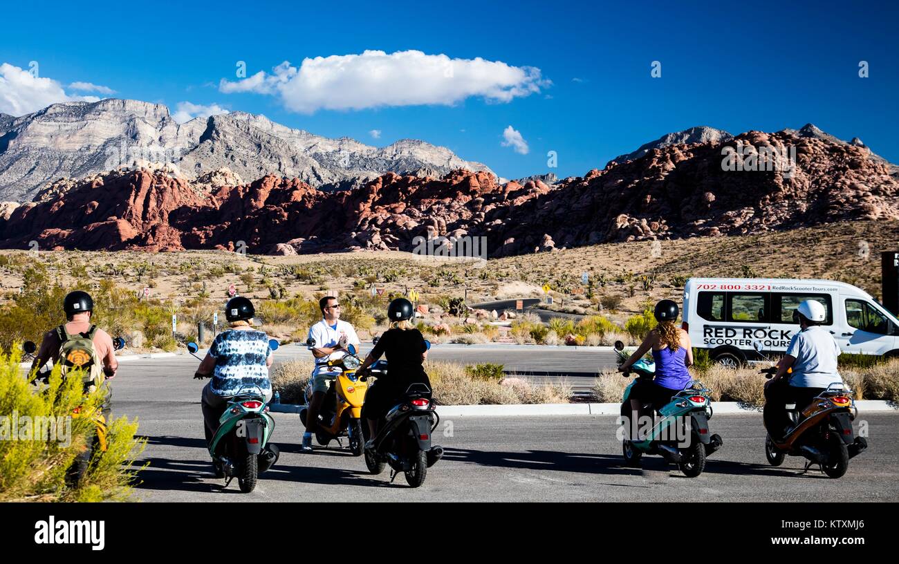 Tourists ride moped scooters through the sandstone rock formations at ...