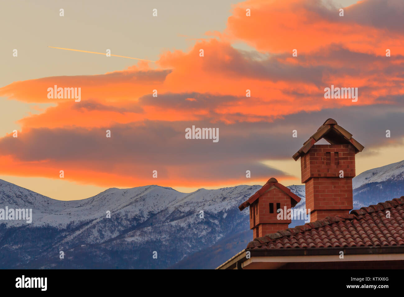 the profiles two chimneys of a house on the background of a sunsetof ...
