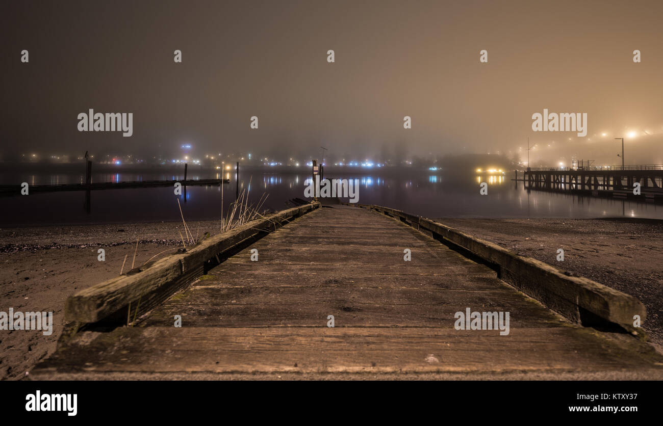 Long dock by the ocean on a foggy night Stock Photo - Alamy