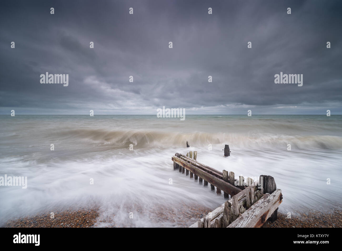 Rustic wooden groyne at Rye Harbour, East Sussex coast, with waves ...