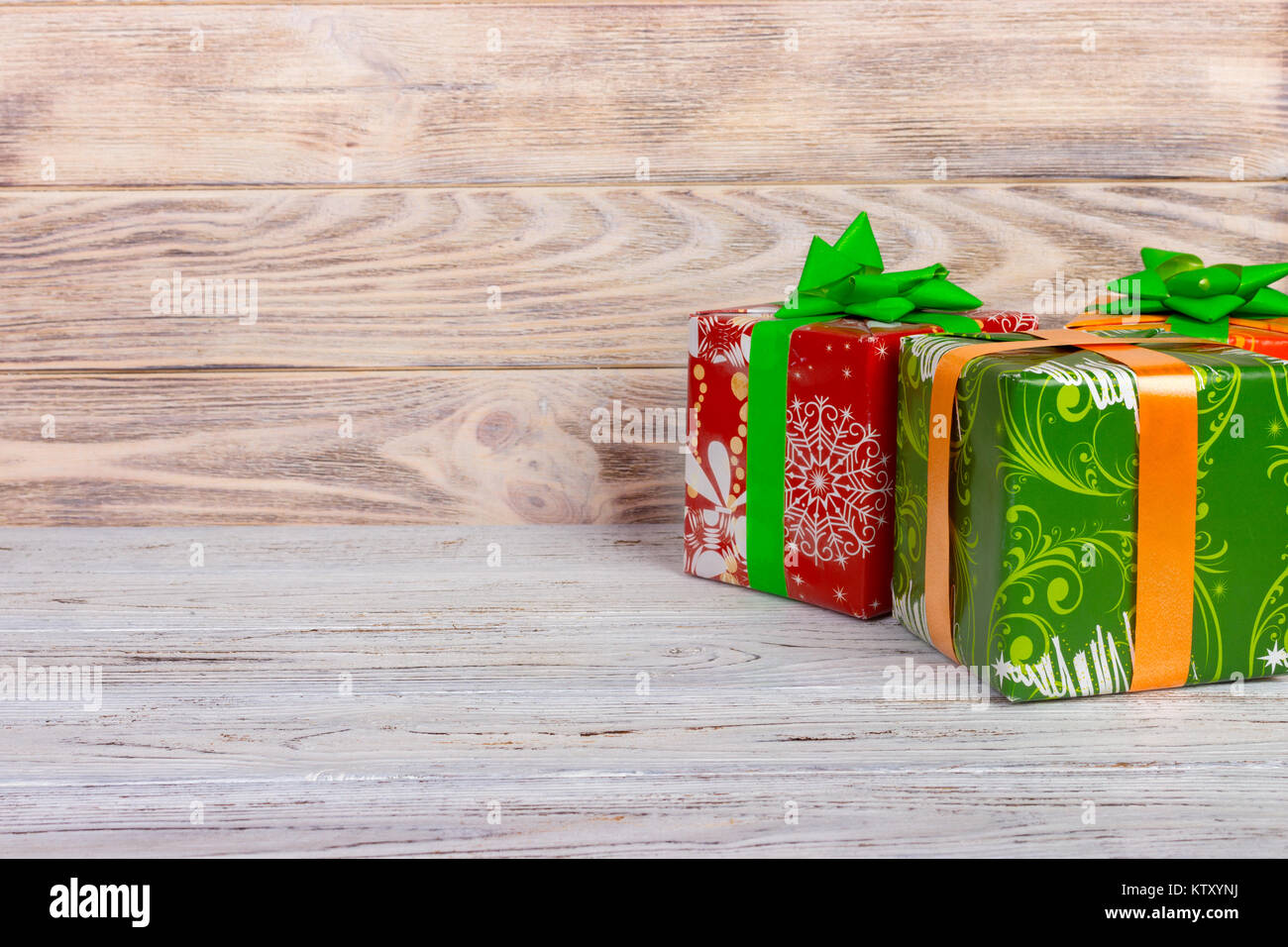 Christmas gift boxes in front of wooden wall. View with copy space for ...