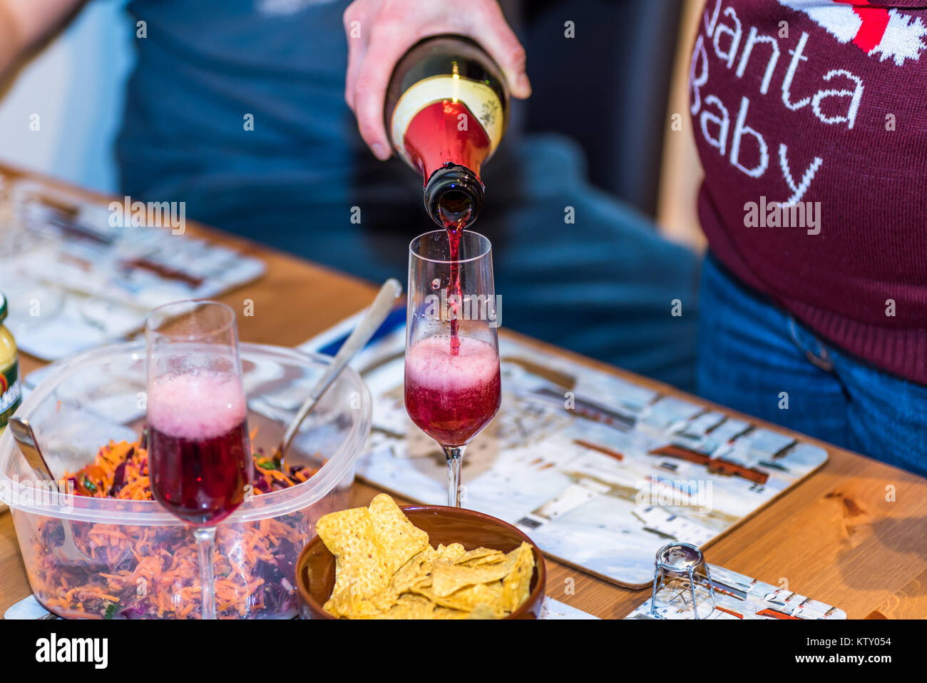 Pregnant female in christmas pullover holding bottle and pouring red ...