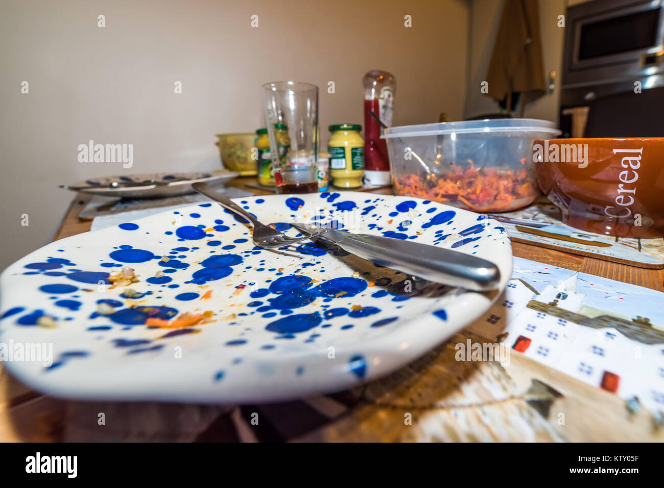 Empty used colorful plate with fork spoon and knife after food eaten on ...