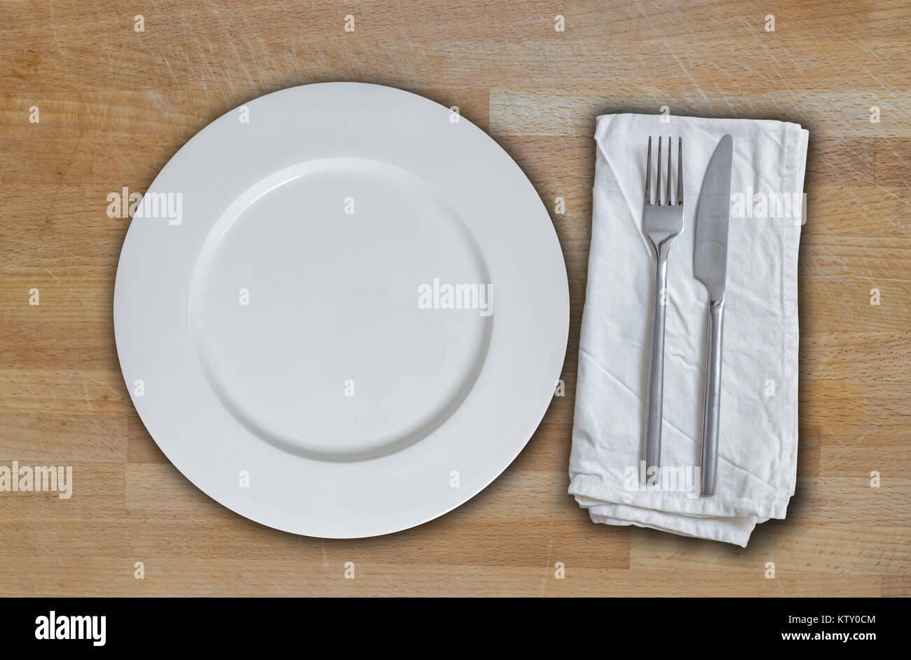Empty plate and cutlery on used wooden board Stock Photo - Alamy