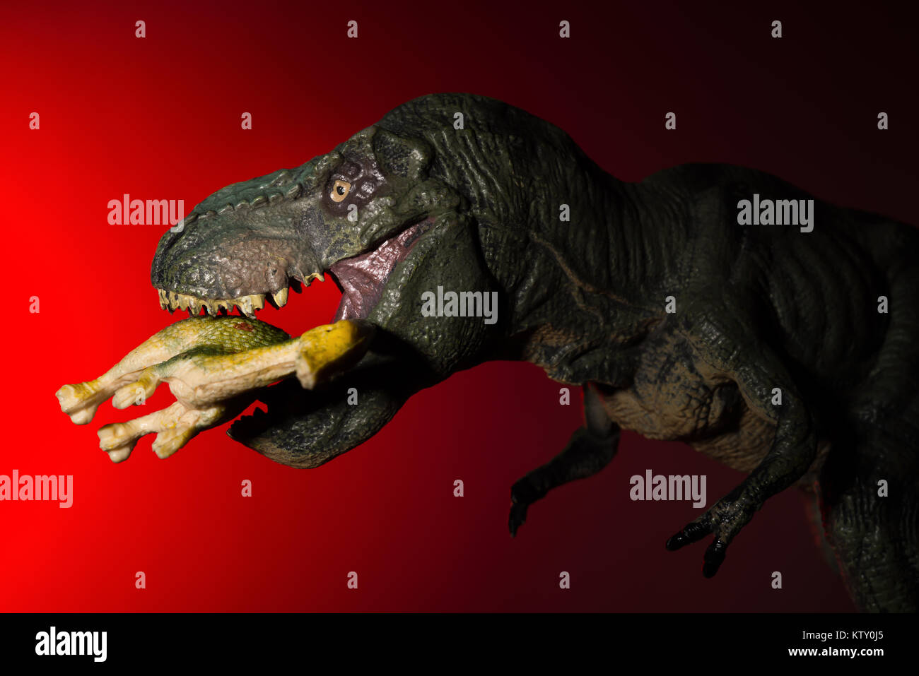 tyrannosaurus biting a smaller dinosaur with spot light on the head and ...