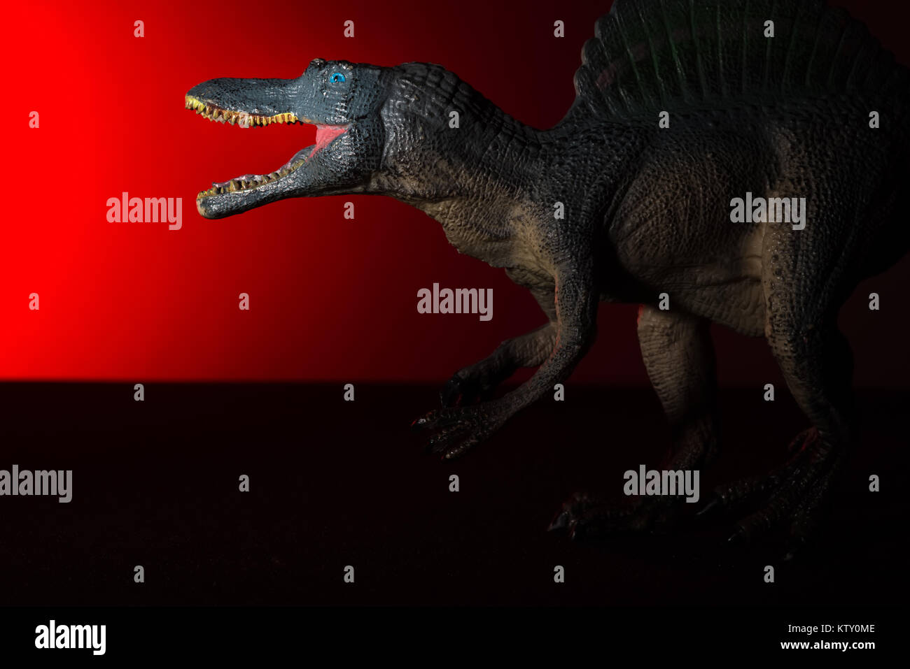 spinosaurus with spot light on the head and red light on background ...