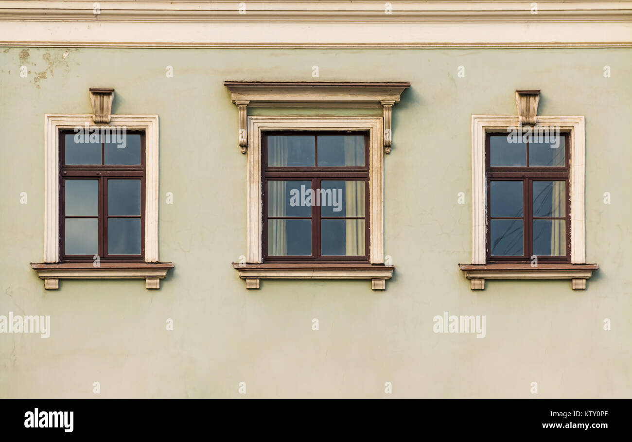 Three windows in a row on the facade of the urban historic building ...
