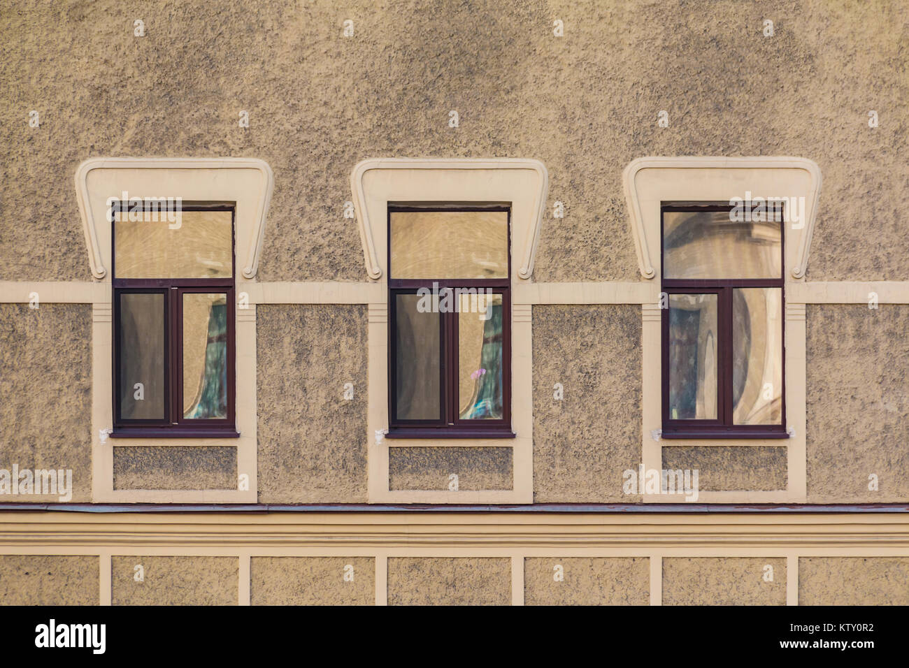Three windows in a row on the facade of the urban historic building ...