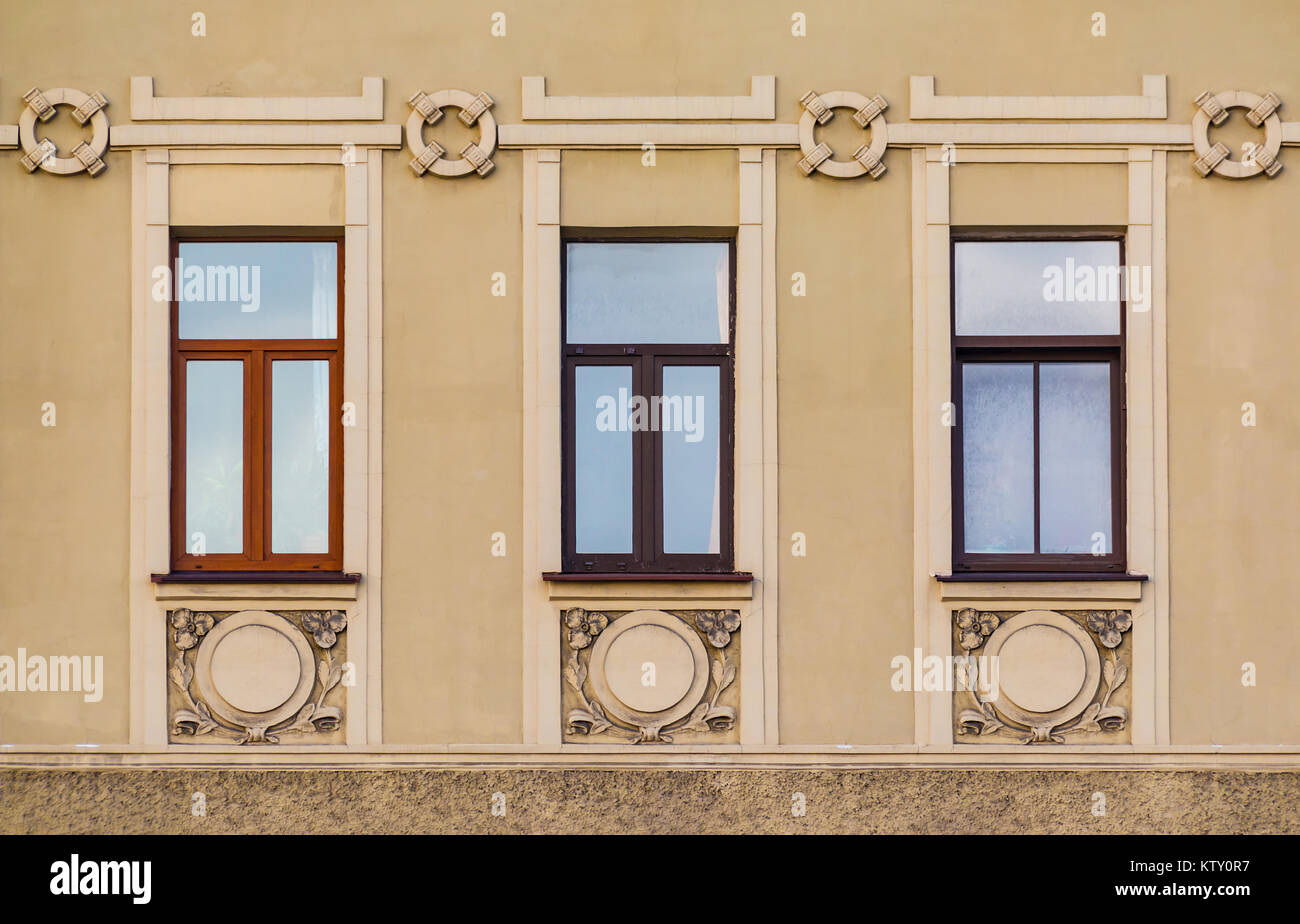 Three windows in a row on the facade of the urban historic building ...