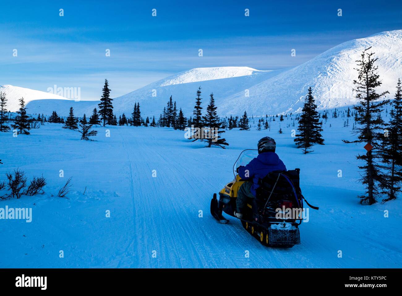 A snowmobiler rides on the snow near the Beaver Creek Wild and Scenic ...