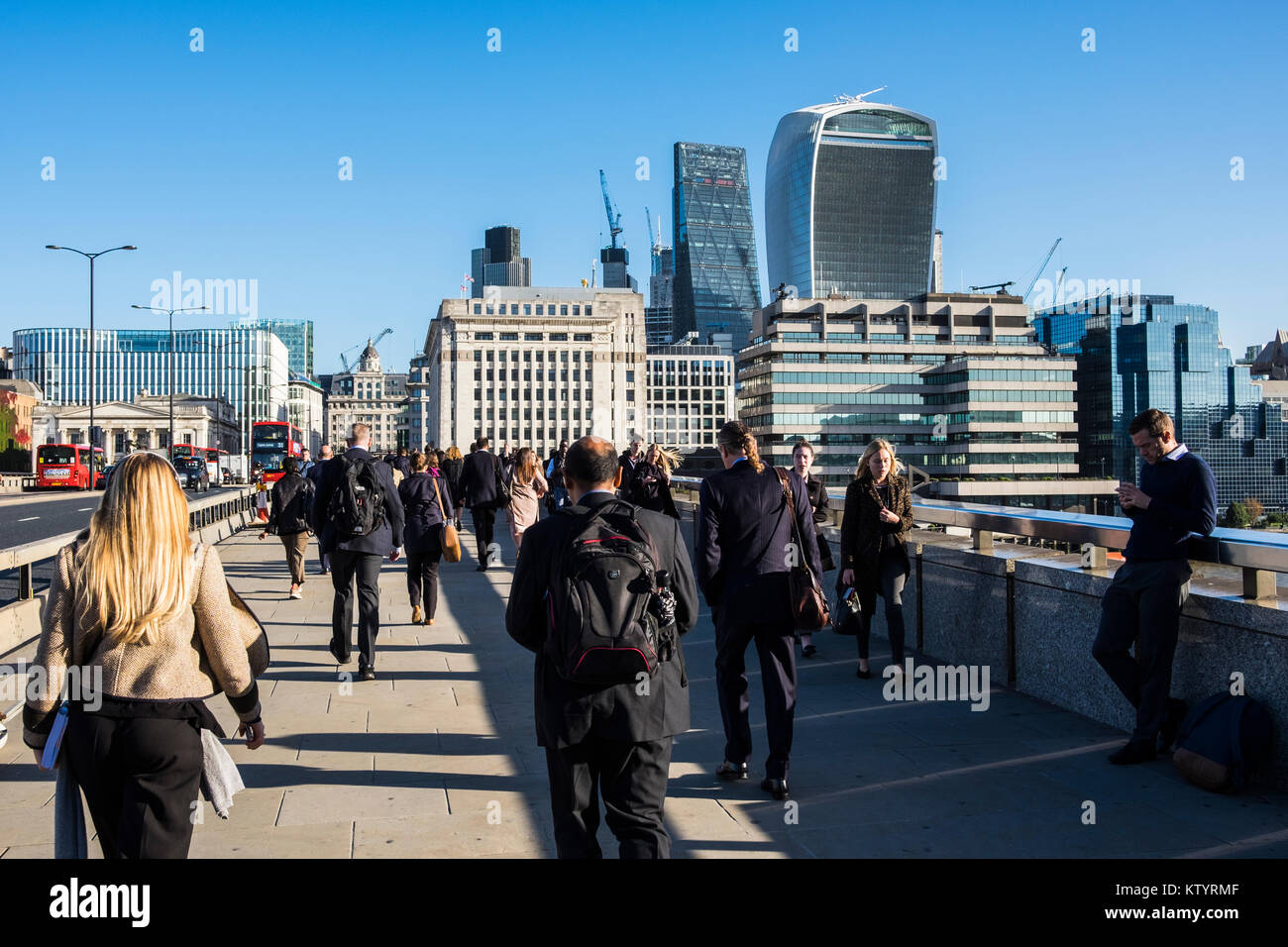 Commuters crossing London Bridge to work in the City of London, England ...
