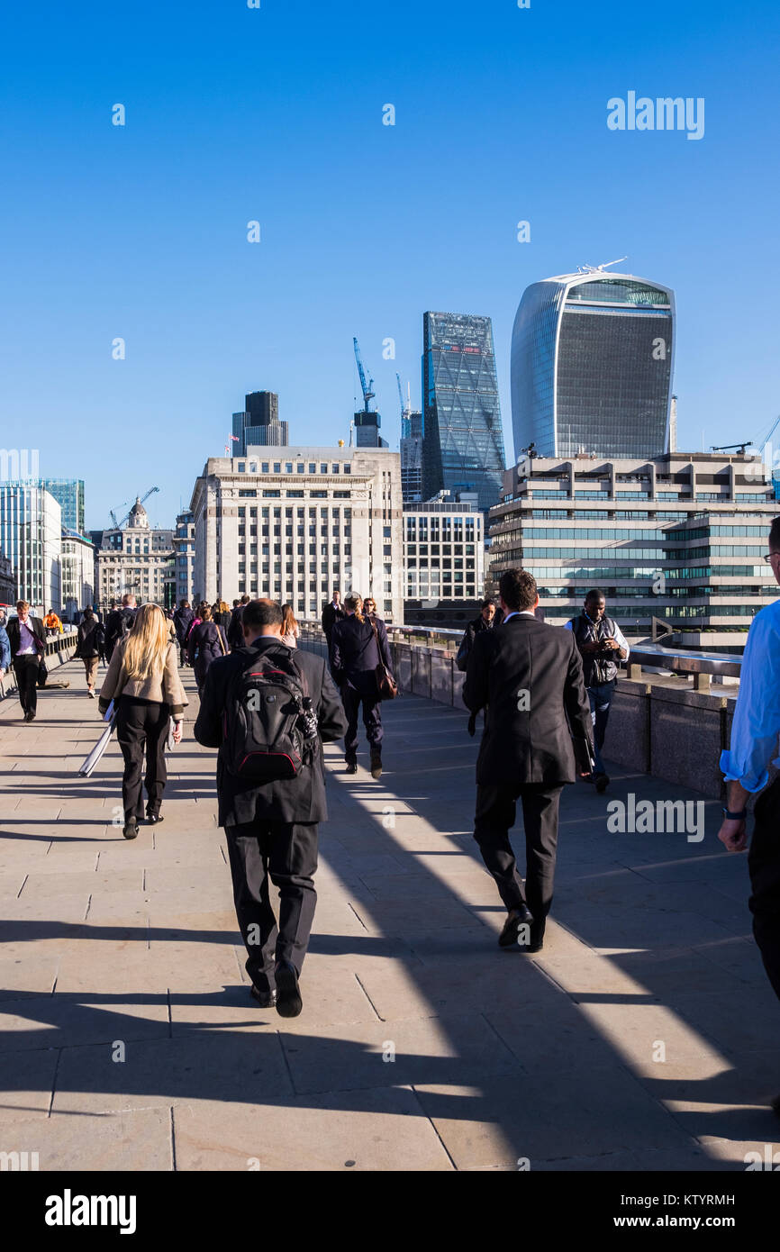 Commuters crossing London Bridge to work in the City of London, England ...