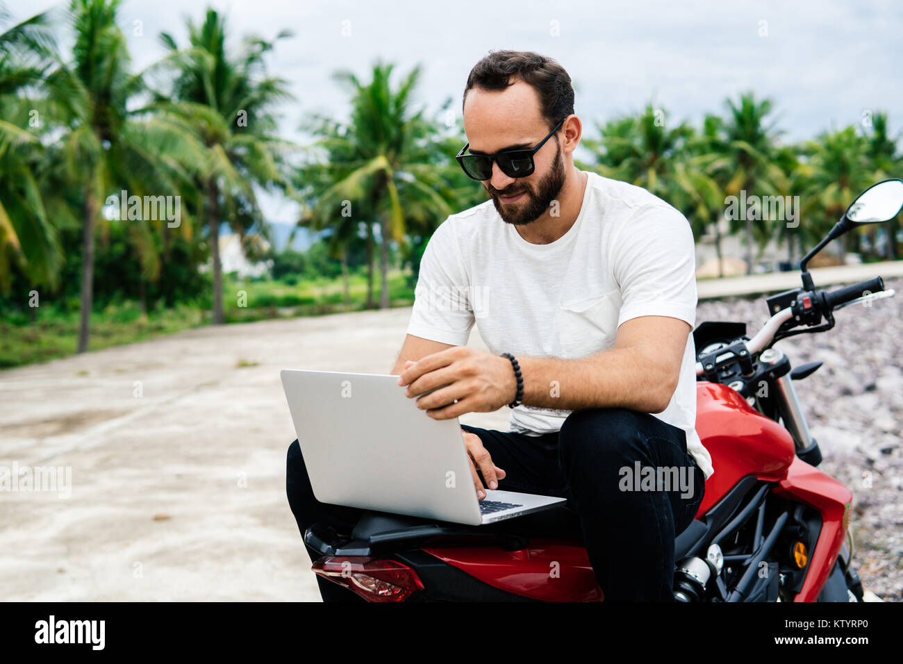 Man working on laptop computer while sitting on his motorcycle Stock ...