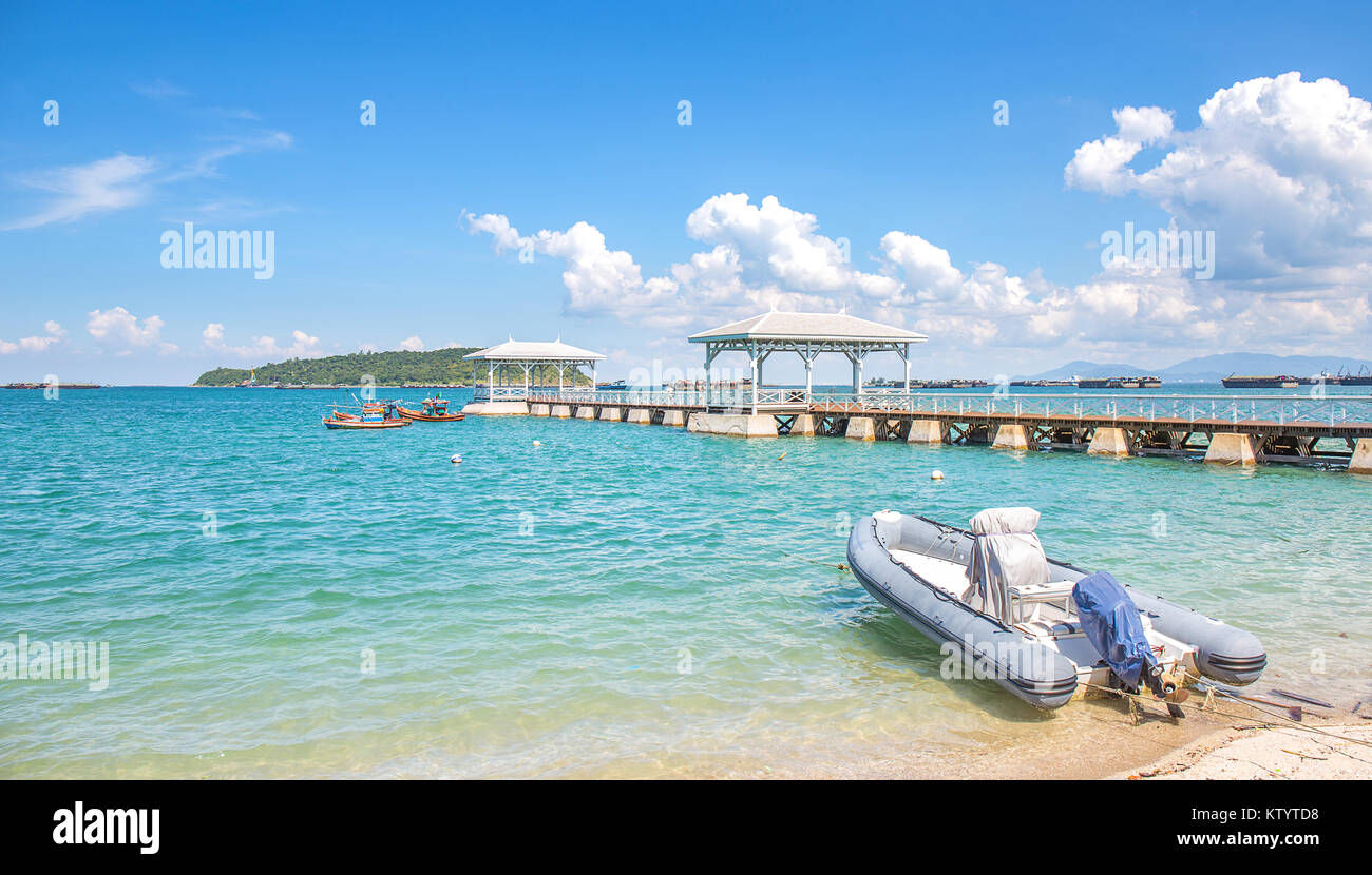 speed boat anchor on white sand beach with white wooden bridge ...