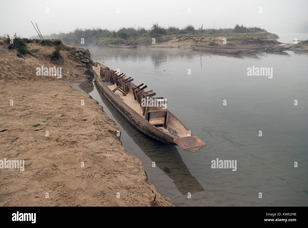 Wooden native canoe, with inverted benches for the seat, near the sandy ...