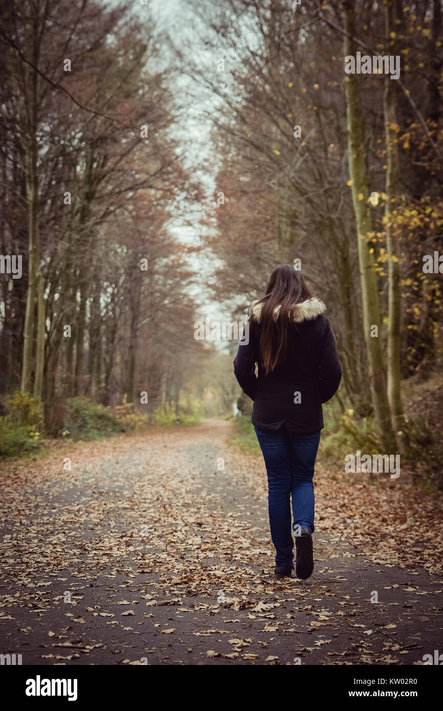 Girl walking alone on a path one autumn Stock Photo - Alamy