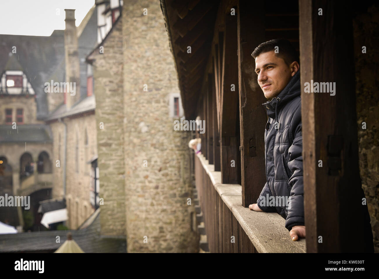 Man staying on a balcony of a medieval castle, tourist Stock Photo - Alamy