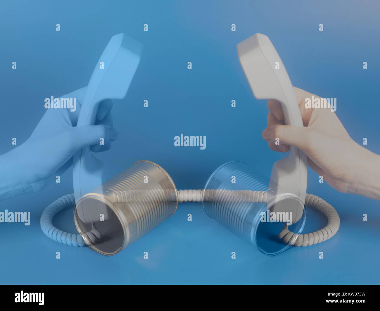 Tin can phone handset holding hand on blue Stock Photo - Alamy