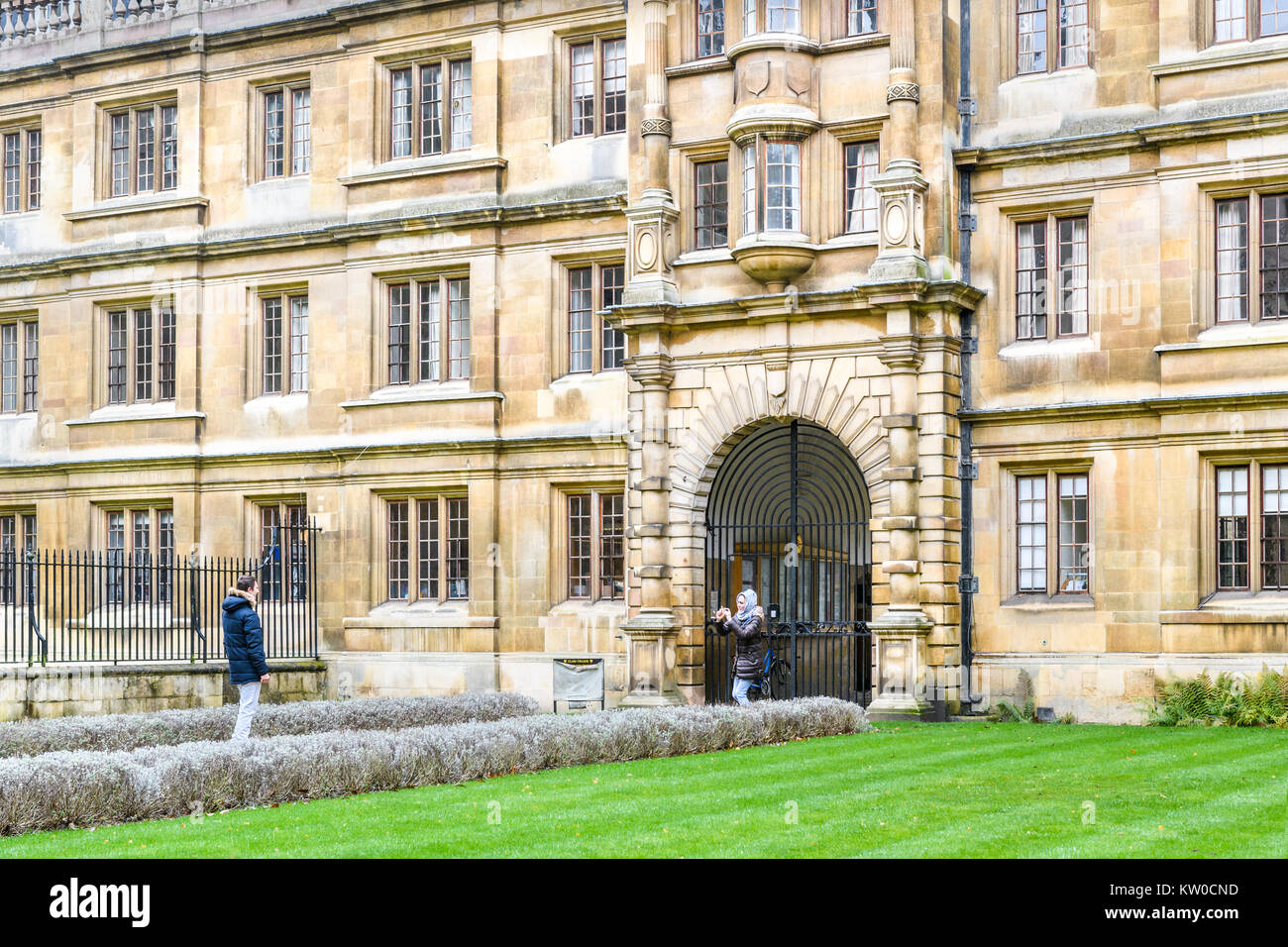 Tourists taking a photograph at the entrance gateway to Clare college ...