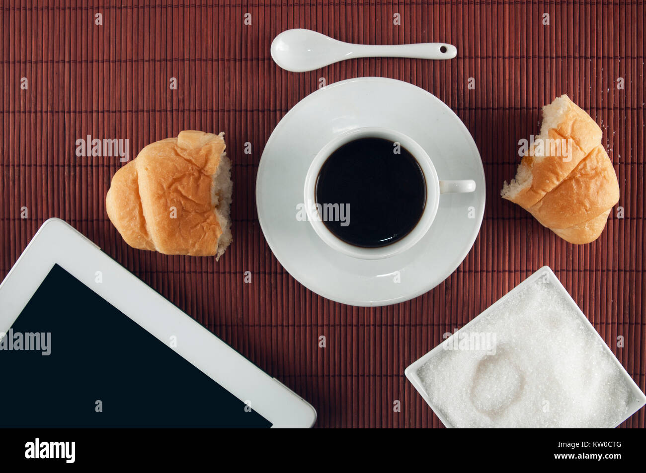 Table ready for breakfast with coffee, croissant and a tablet Stock ...