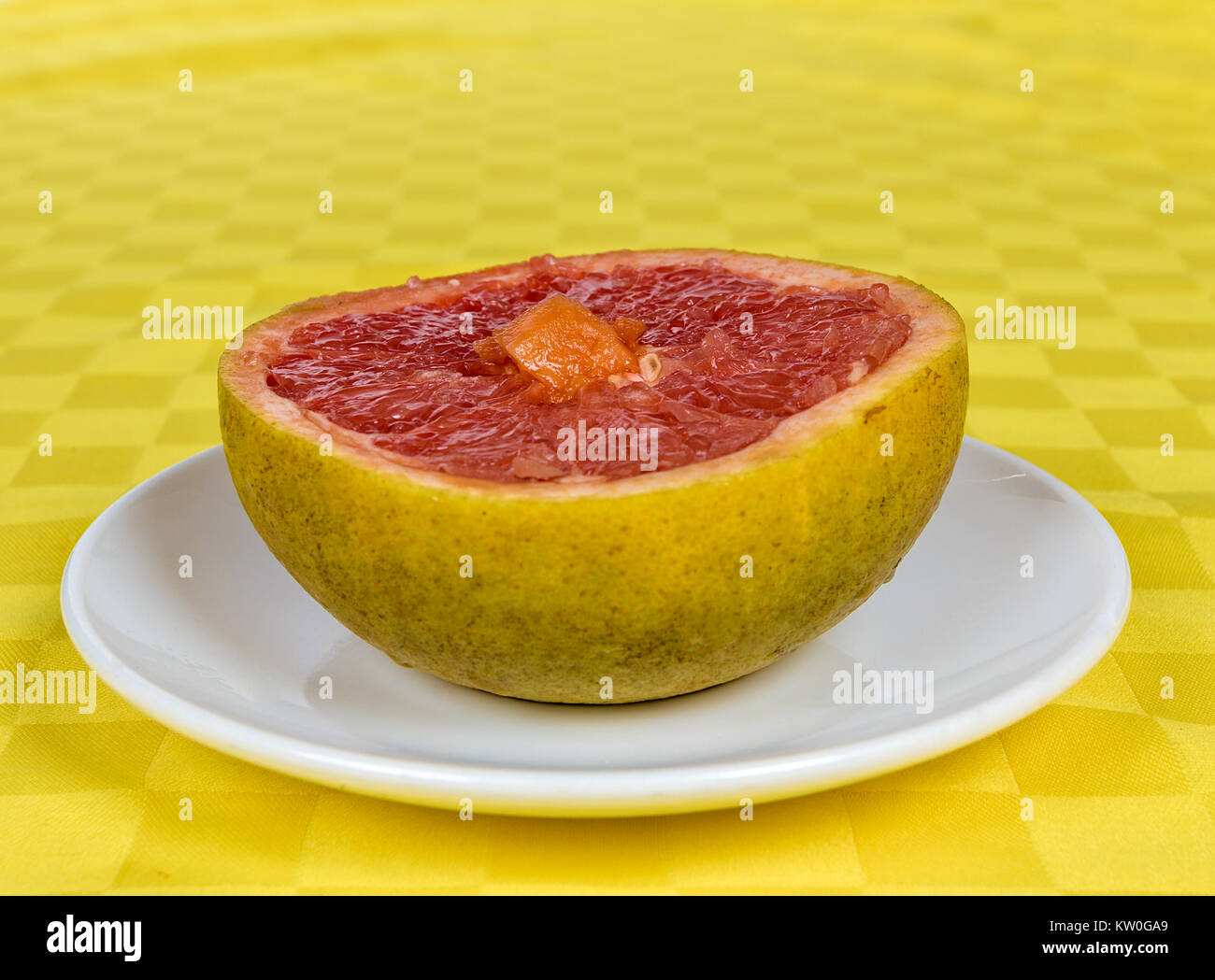 One half of a red grapefruit served in a white dish Stock Photo - Alamy