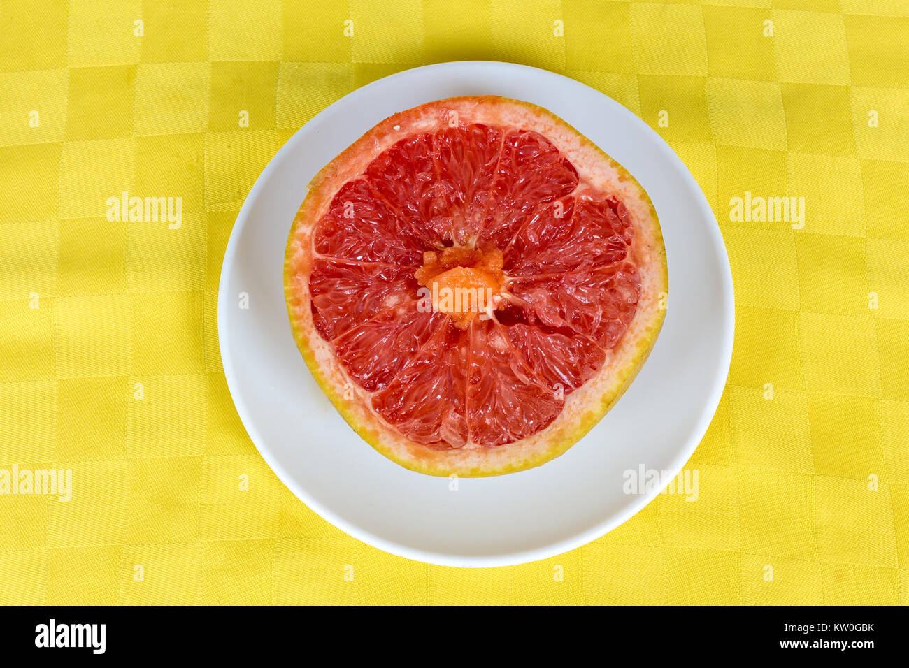 One half of a red grapefruit served in a white dish Stock Photo - Alamy
