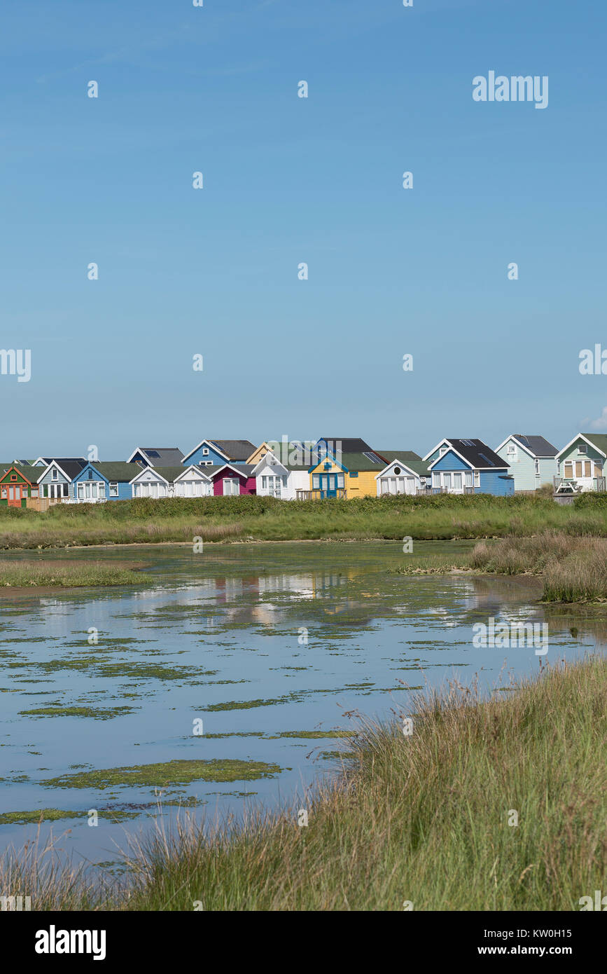 View across the salt marshes on Hengistbury Head to the beach huts on Mudeford Spit in Dorset ...