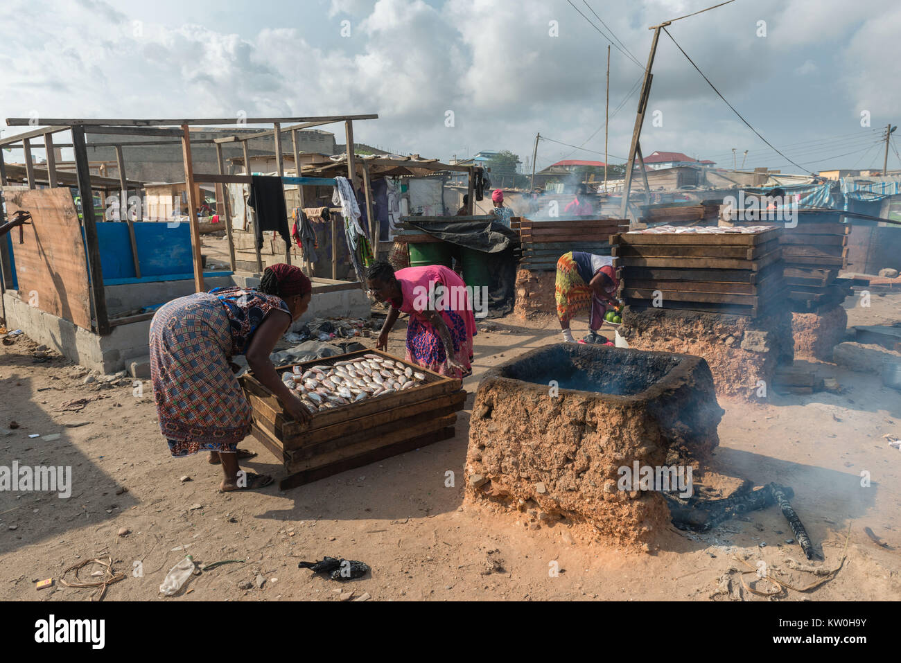 Two women smoking fish over a clay oven, Jamestown Fishing Village ...