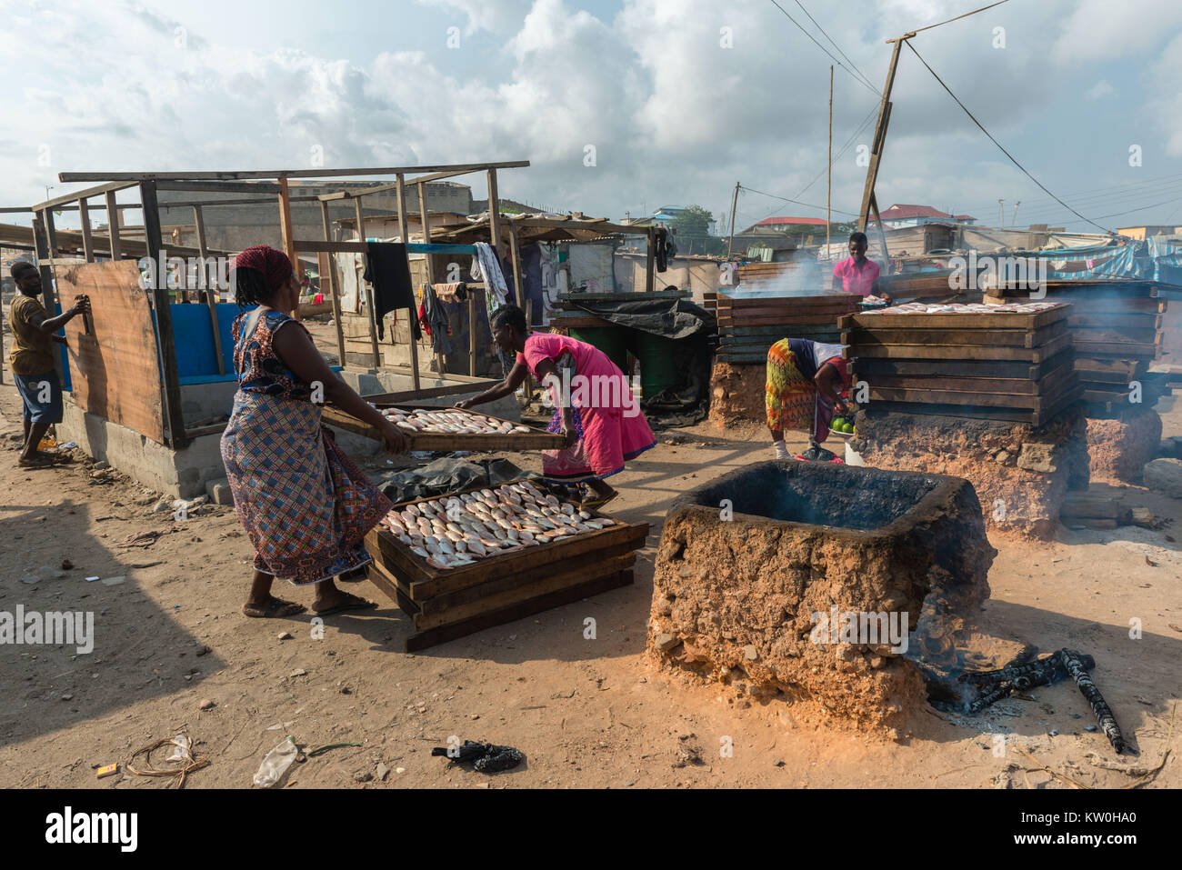 Two women smoking fish over a clay oven, Jamestown Fishing Village ...